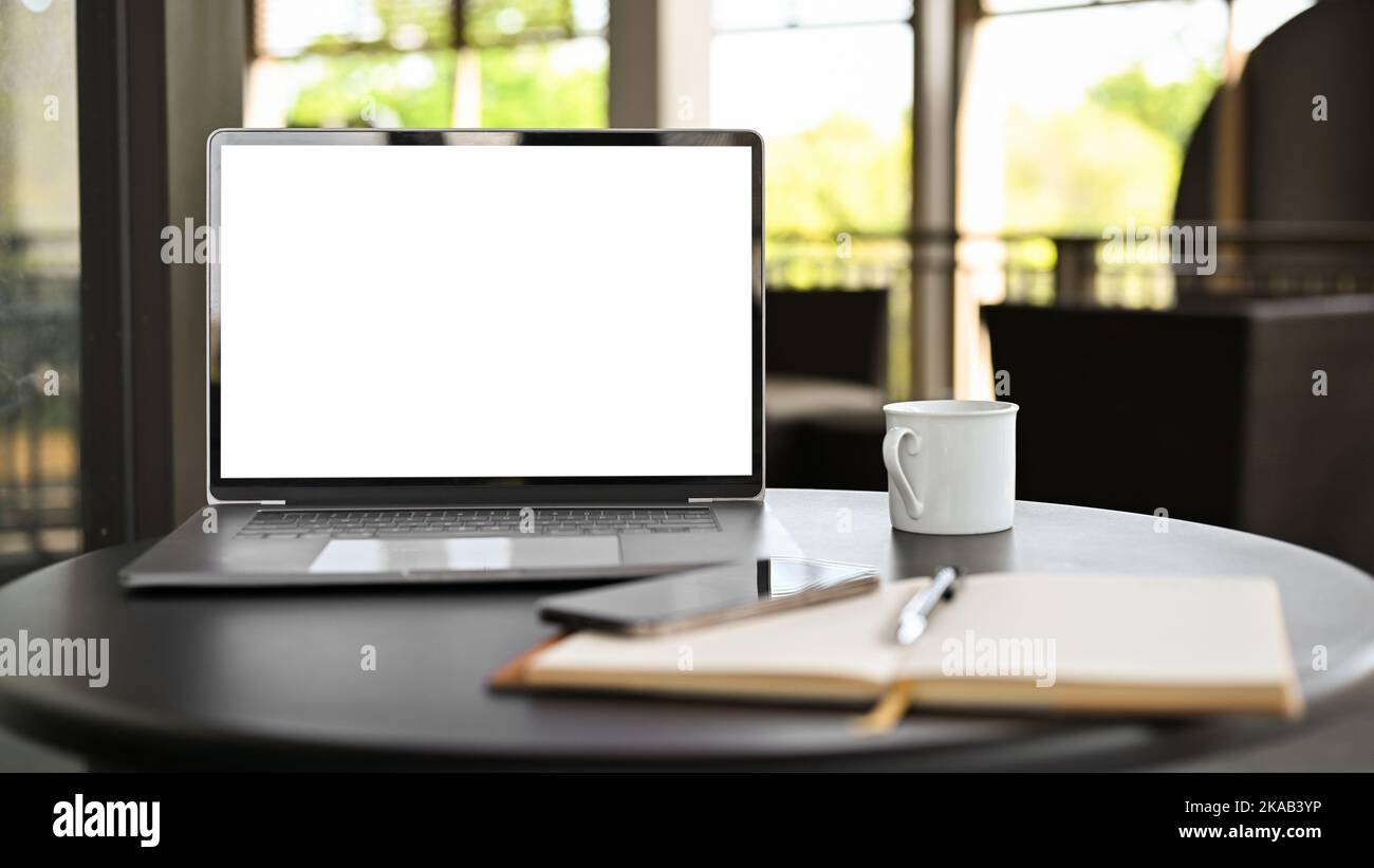 Workspace in modern coffee shop or co-working space with laptop white ...