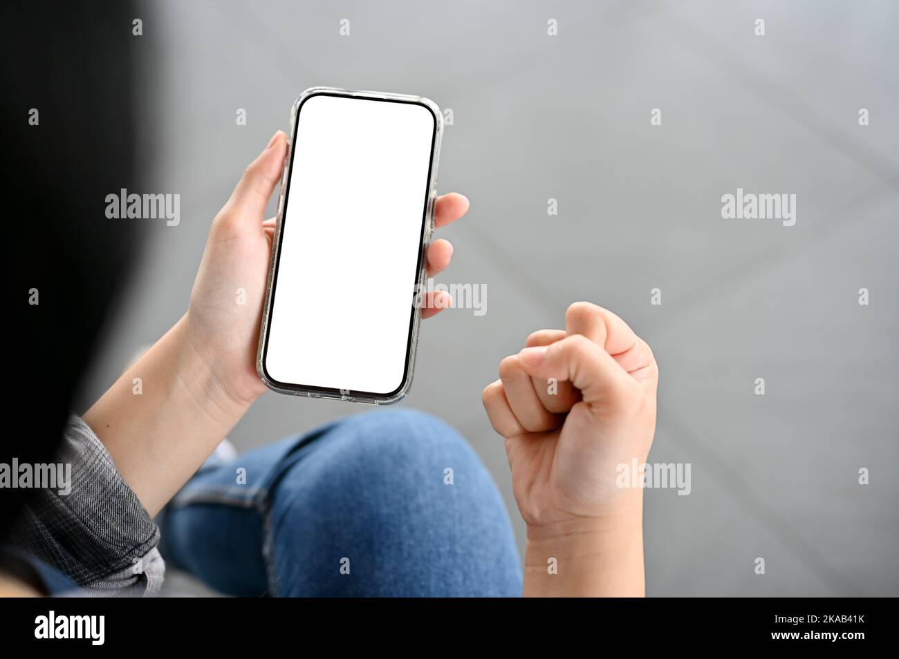 A female hand holding a smartphone white screen mockup and showing ...