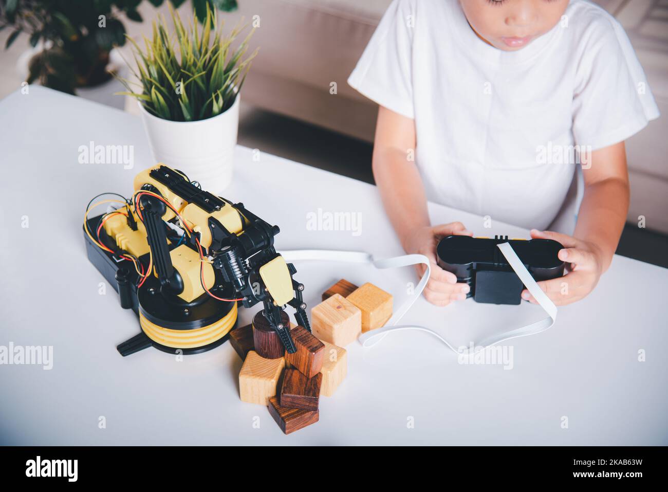 Happy Asian little kid boy using remote control playing robotic machine ...