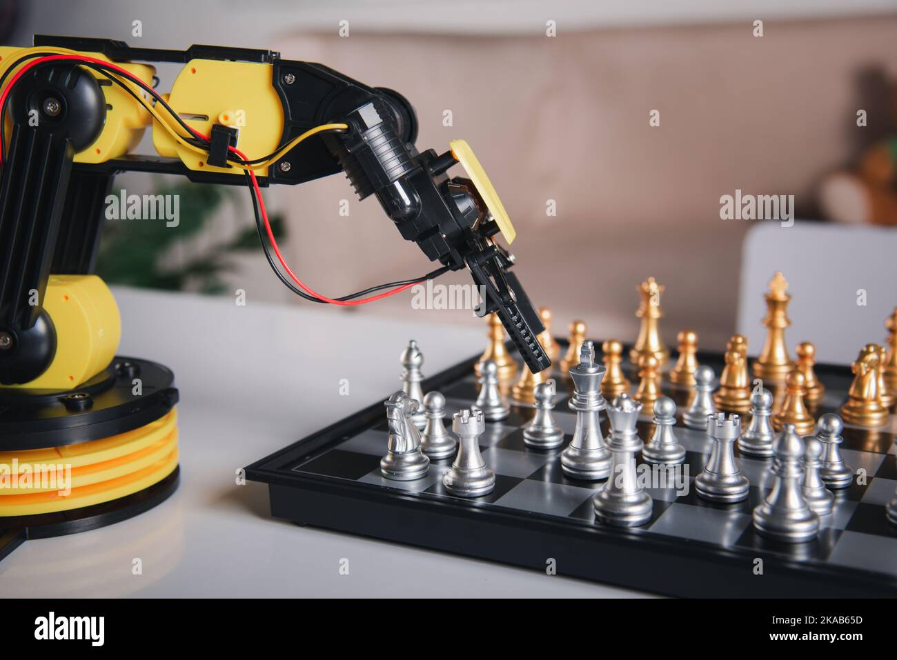 Closeup yellow robot arm playing move chess on chessboard Stock Photo ...
