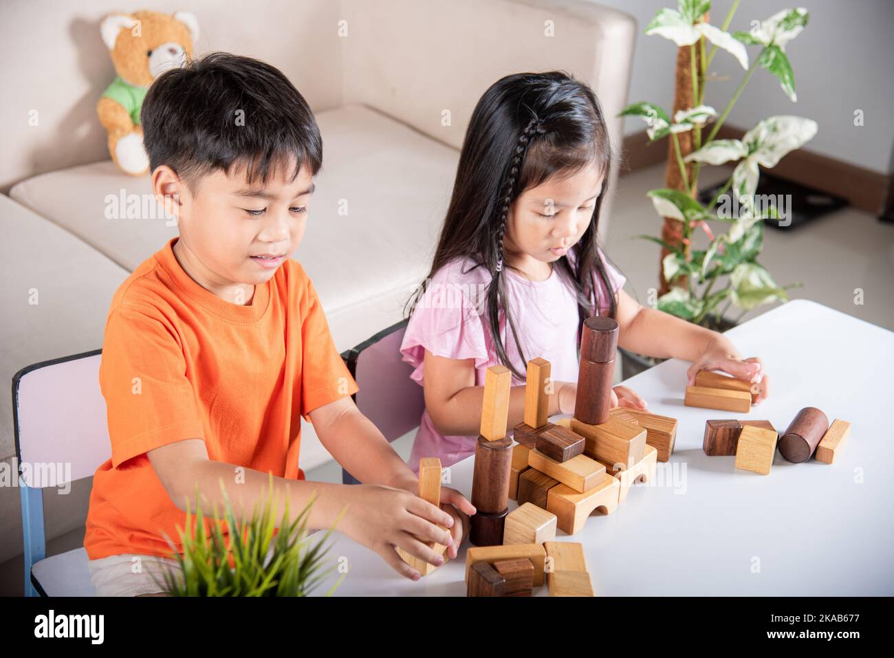 Children boy and girl playing with constructor wooden block building ...