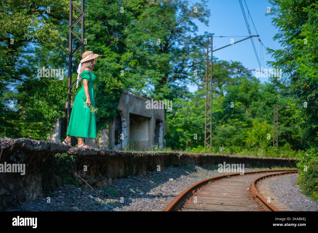 a lovely woman in a green dress is walking by the railway Stock Photo ...