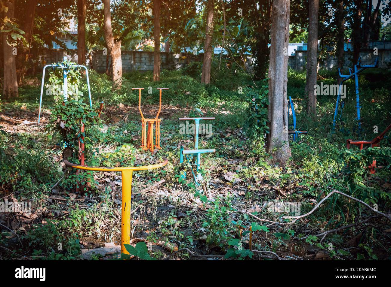 Old outdoor exercise equipment so worn out and covered in trees in ...
