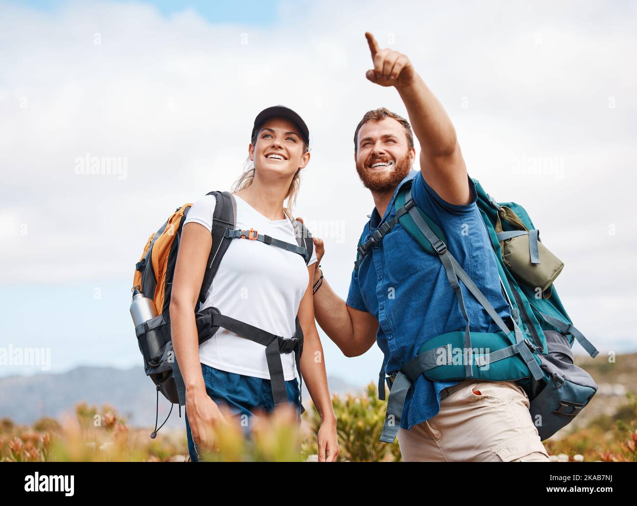 Hiking, happy and couple in nature, relax and smile, hand and pointing ...