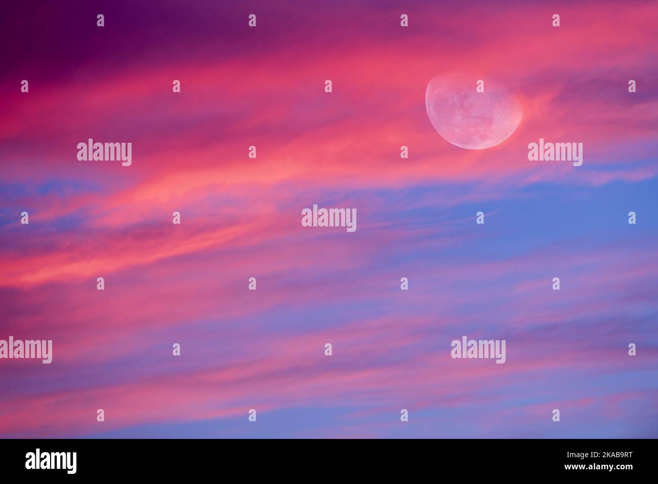 The Moon Is Rising Among A Colorful Cloud Filled Sunset Sky High ...