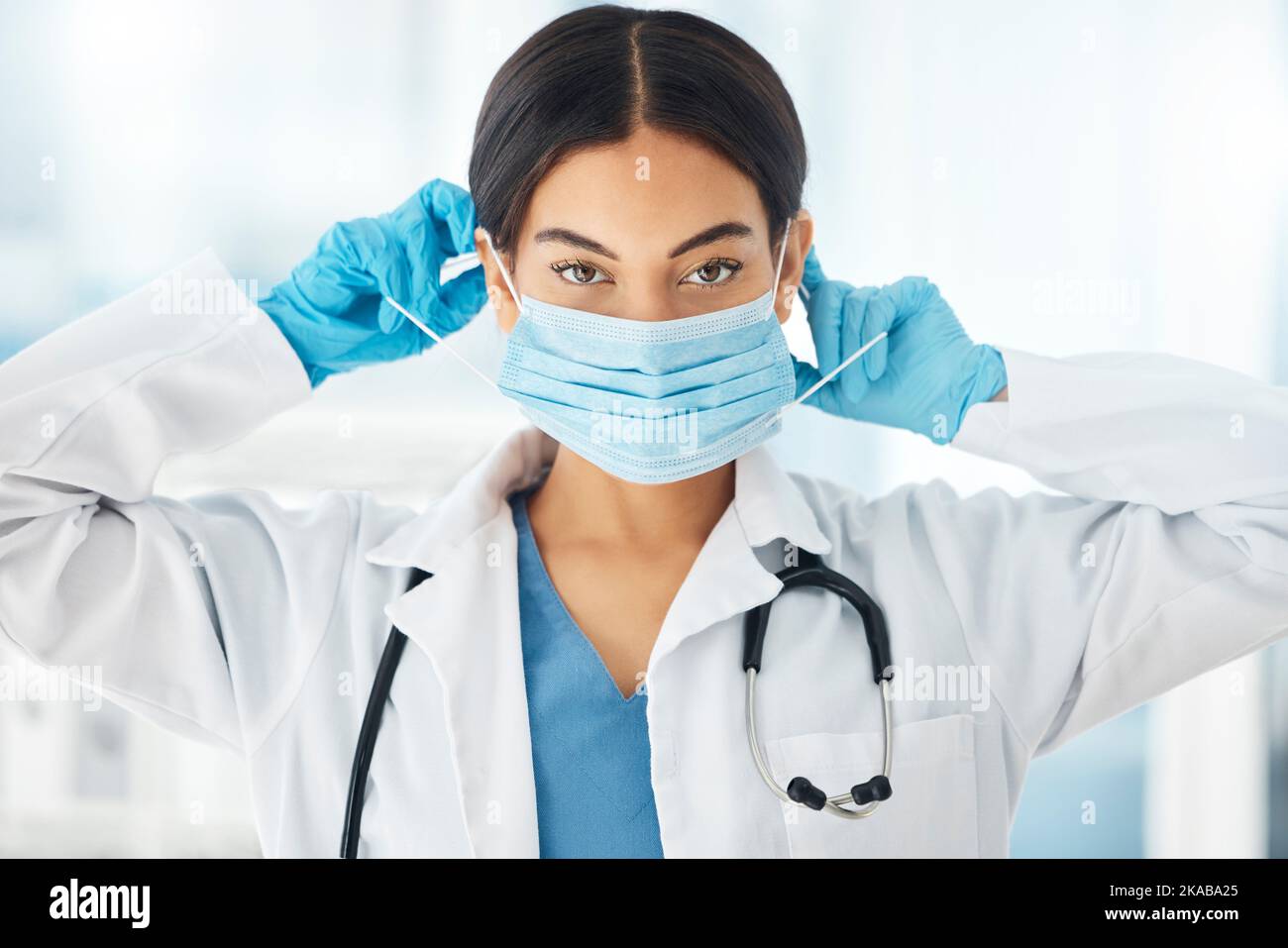 Healthcare, covid and doctor hands on face mask for compliance in a ...