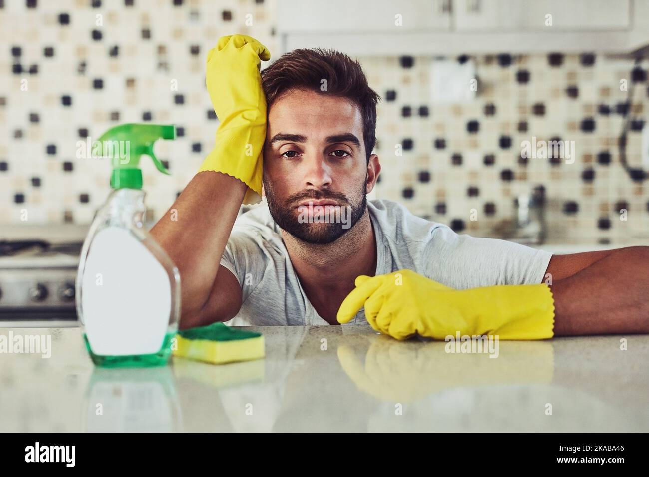 Housework is not just for women. a handsome young man cleaning his home ...