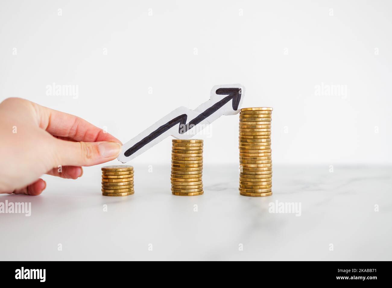 growing stacks of coins with arrow pointing upward, metaphor of ...