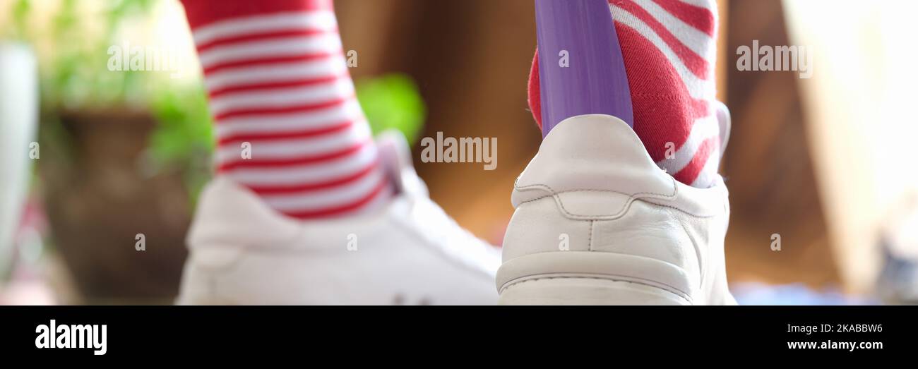 Person puts a shoehorn into sneakers closeup Stock Photo - Alamy