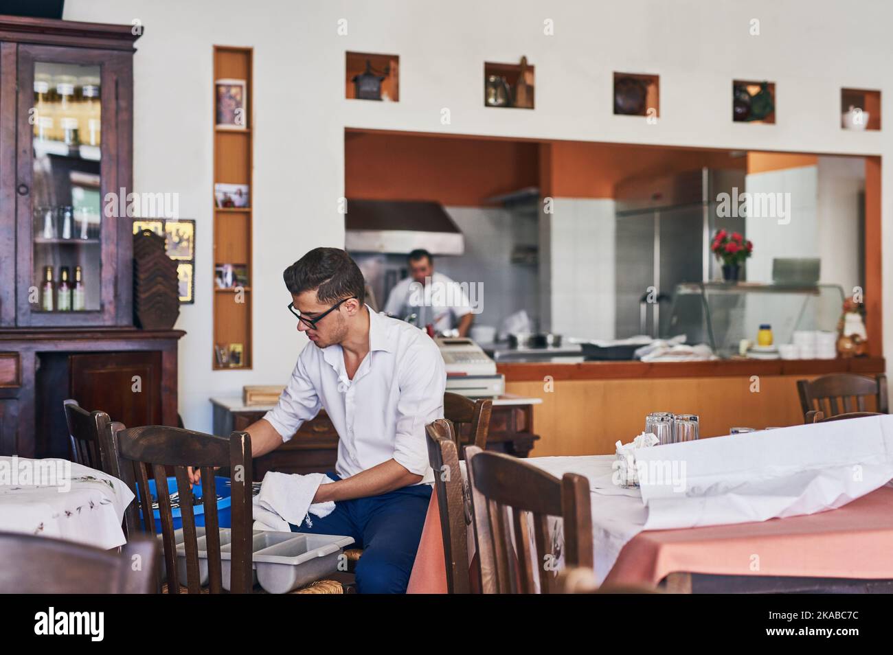 Preparing the restaurant before customers arrive. men working at a ...