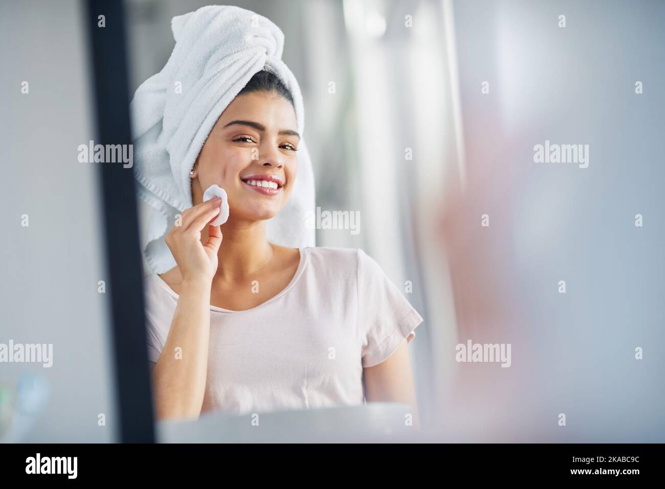 Cleansing her skin to reveal her natural beauty. a beautiful young ...