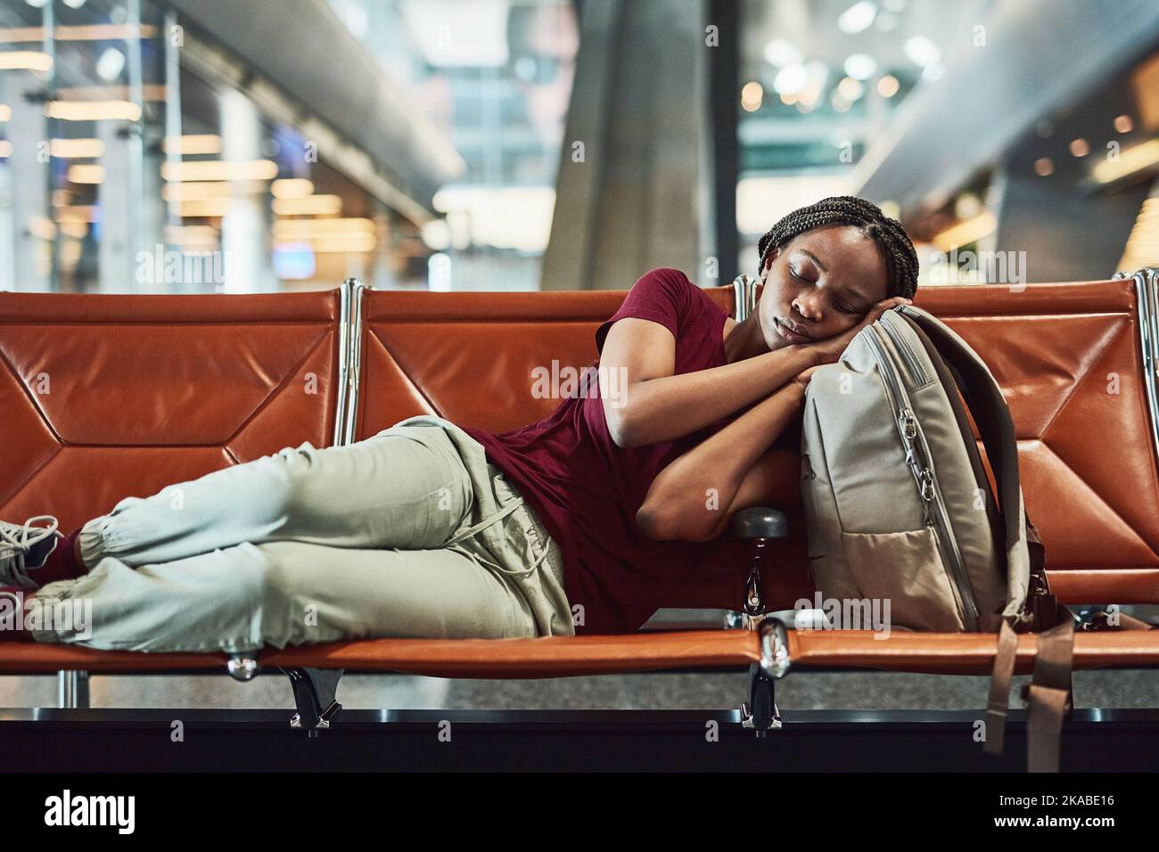 The wait can be quite long. a young woman falling asleep at the airport ...