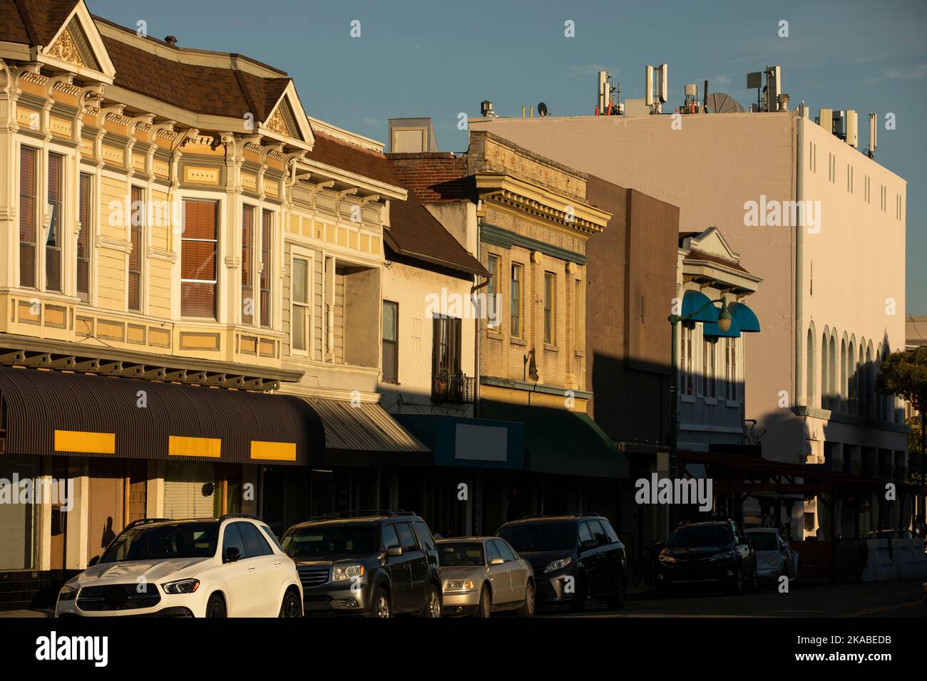 Late afternoon sun shines on the historic bay area city of downtown Alameda, California, USA ...