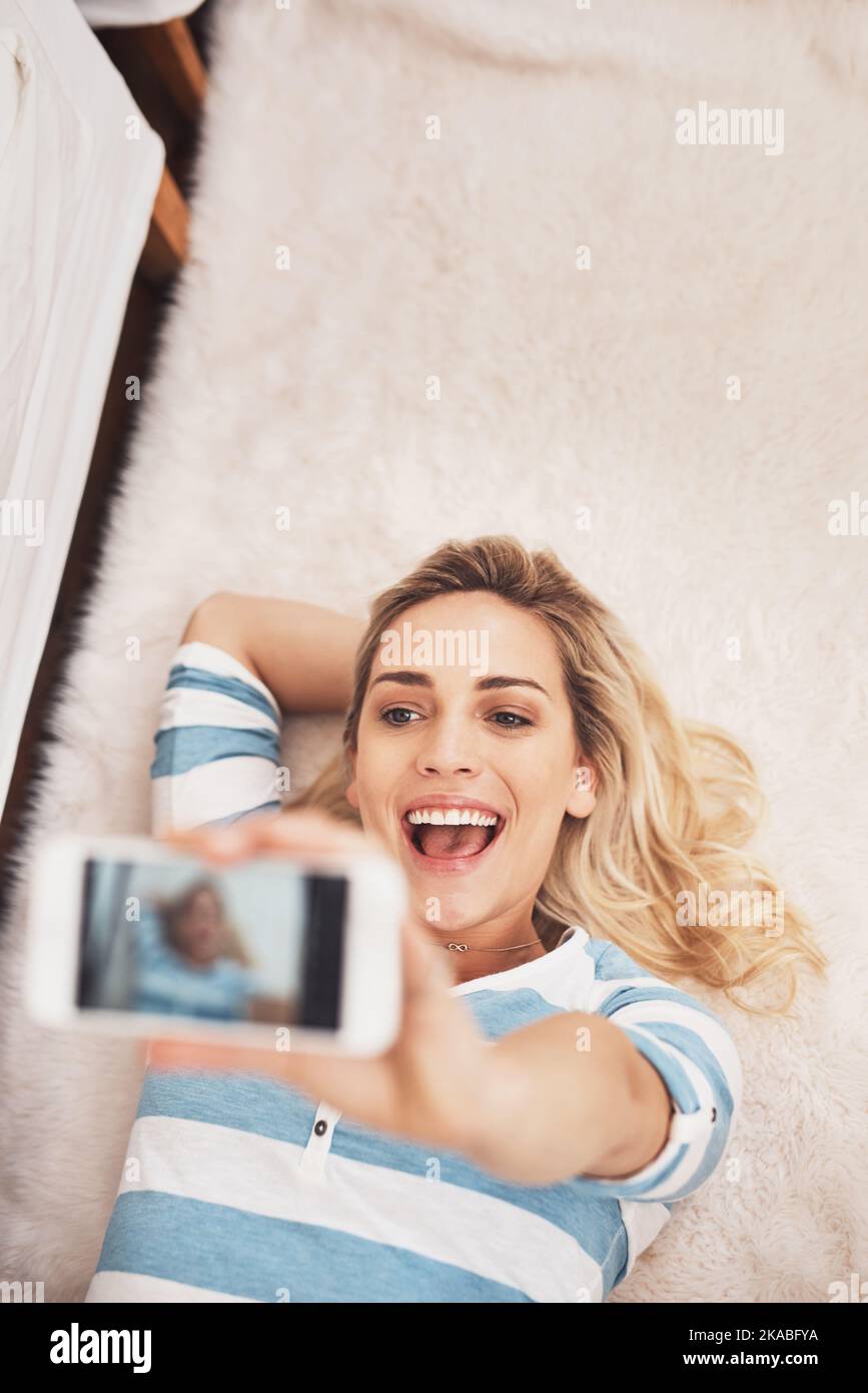 Enjoying her time at home. High angle shot of a young woman taking a ...