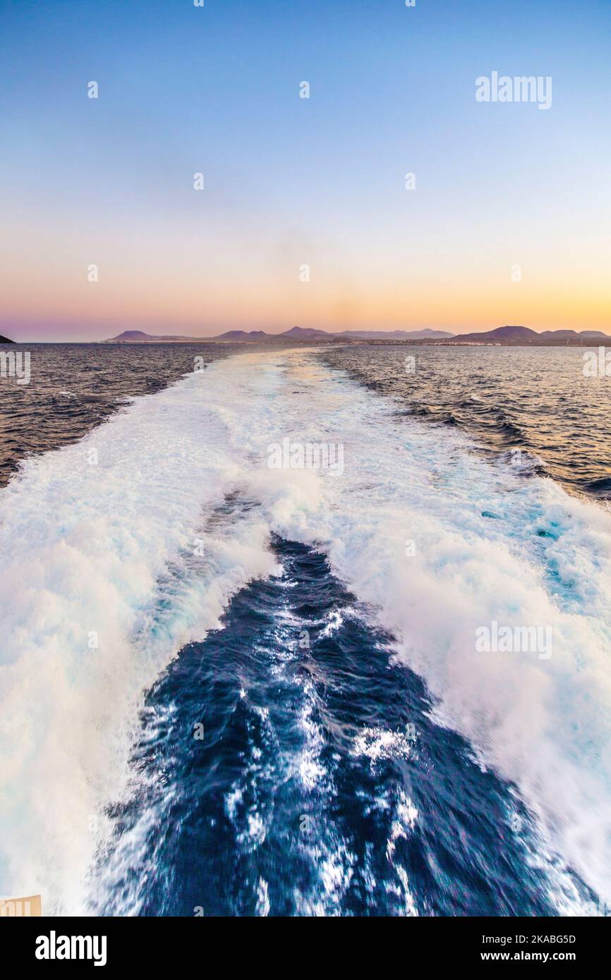 trail of the ship with the island in the background Stock Photo - Alamy