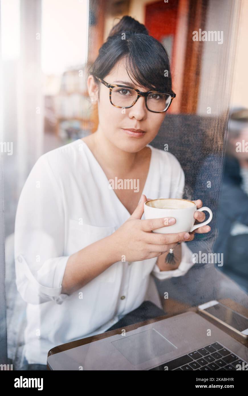 Coffee keeps me going. a beautiful young woman having a sip of her ...