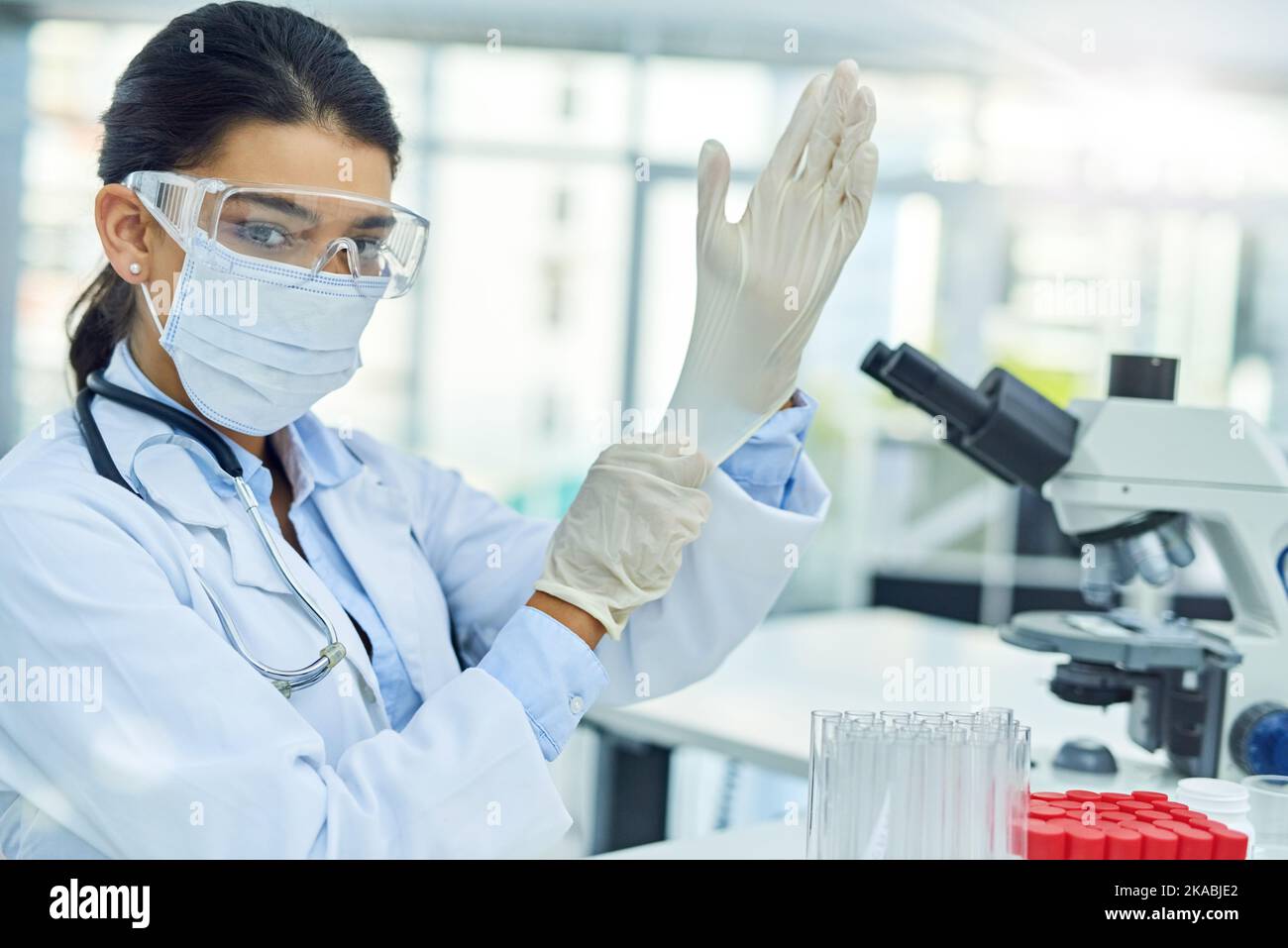 Lets get experimenting. Portrait of a young scientist putting on ...
