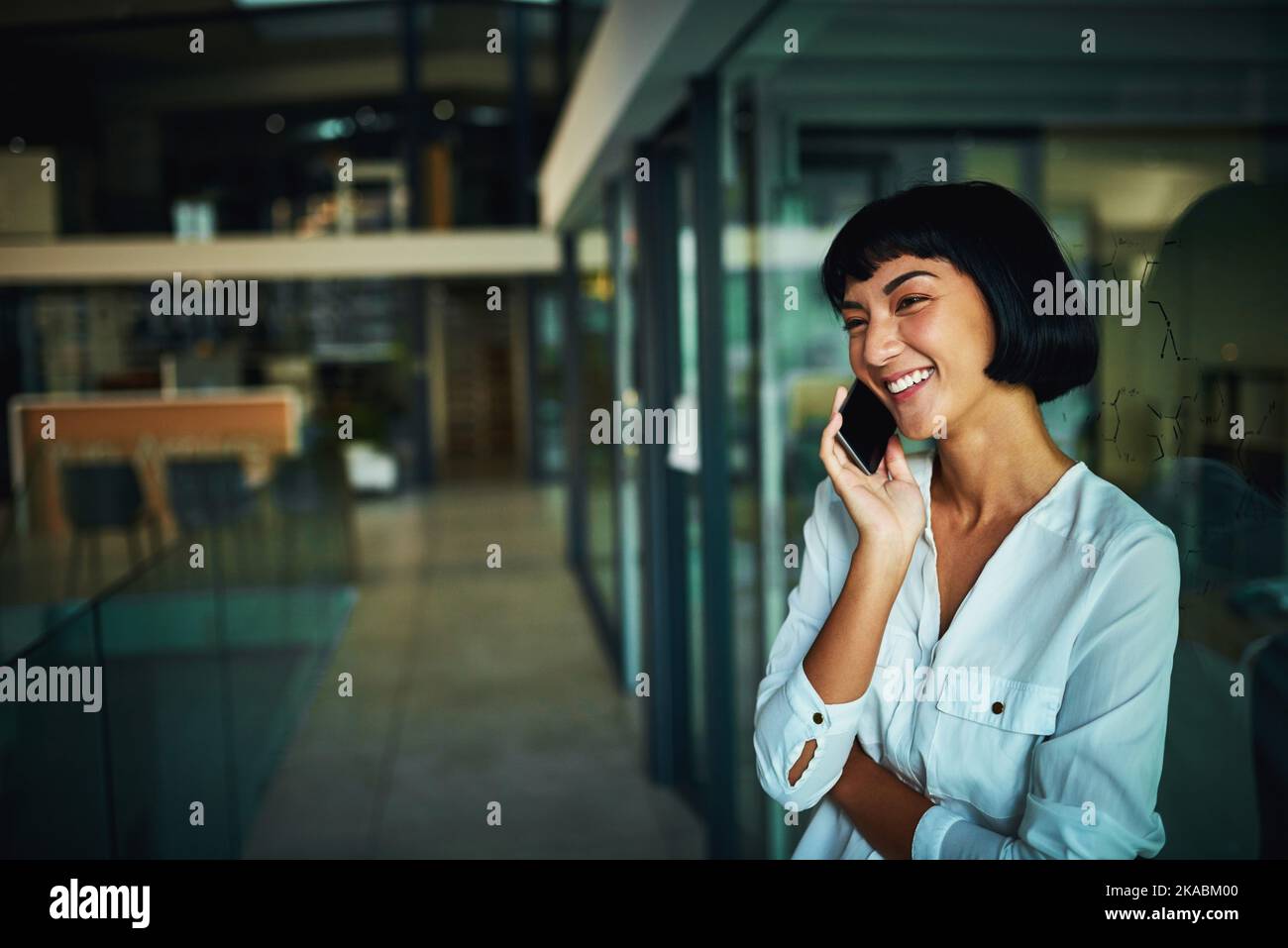 Tell me more...a young businesswoman using a mobile phone during a late ...