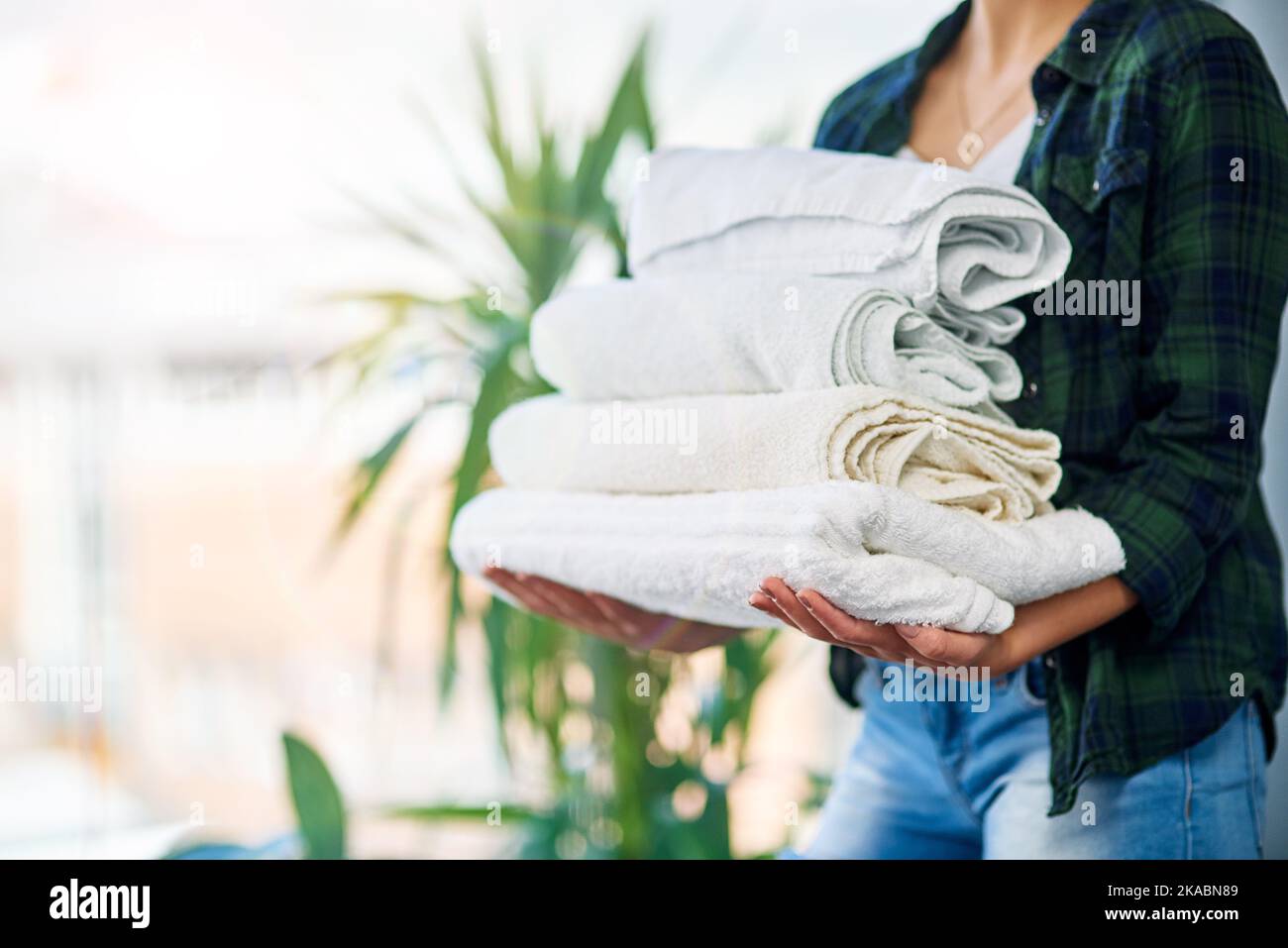Thats another load. an unrecognizable woman carrying a pile of towels ...