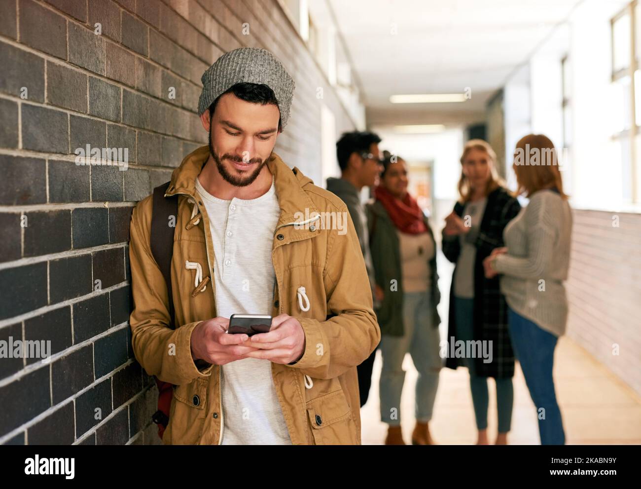 Staying connected on campus. a young male university student standing ...