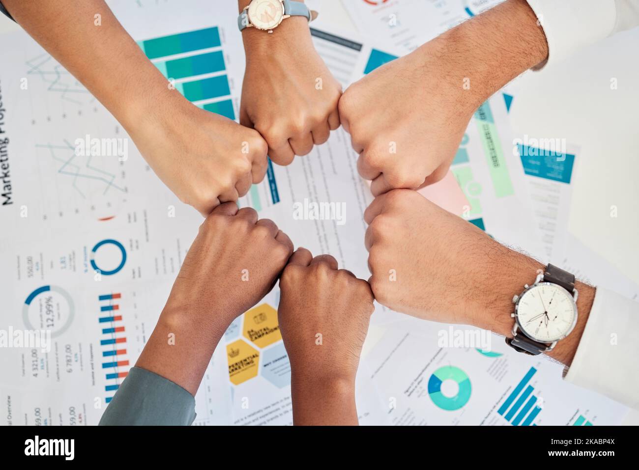 Finance, accounting and team fist bump from above over documents for ...