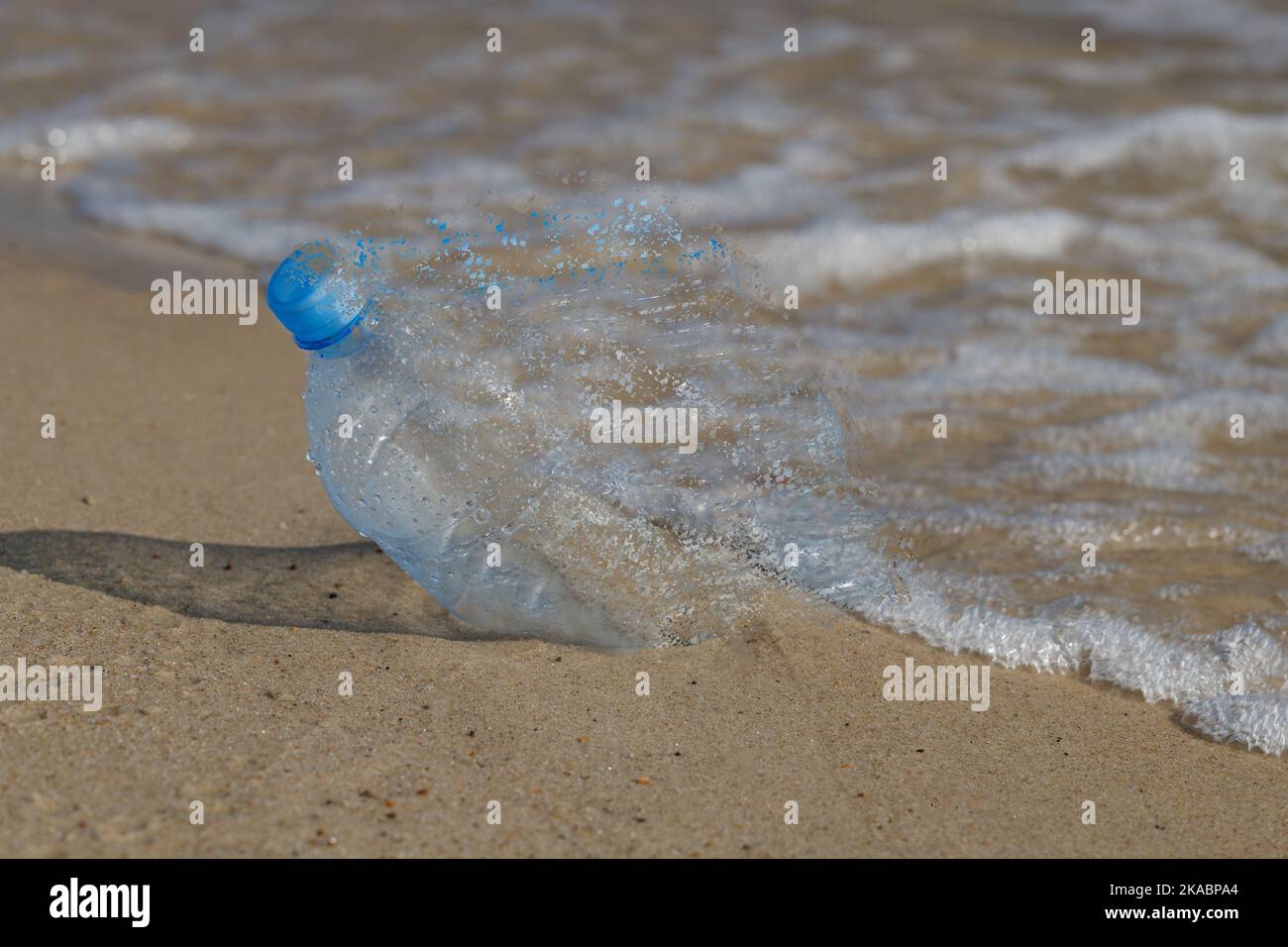 Blue plastic bottle on sea coast, pollution ecosystem planet save ...