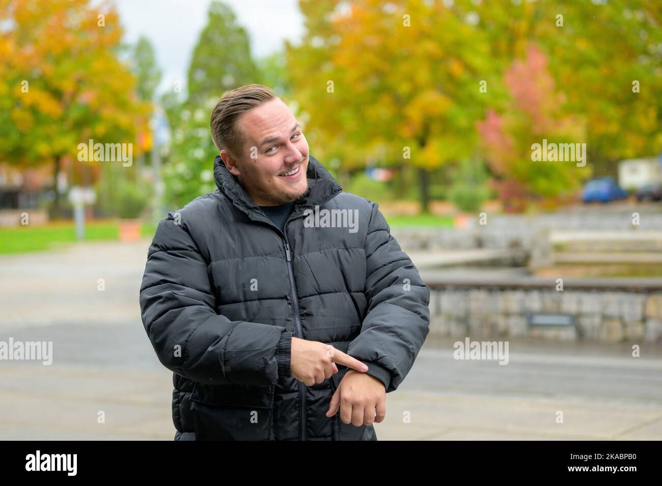 Young man looks at the camera with a smiling and challenging smile and ...