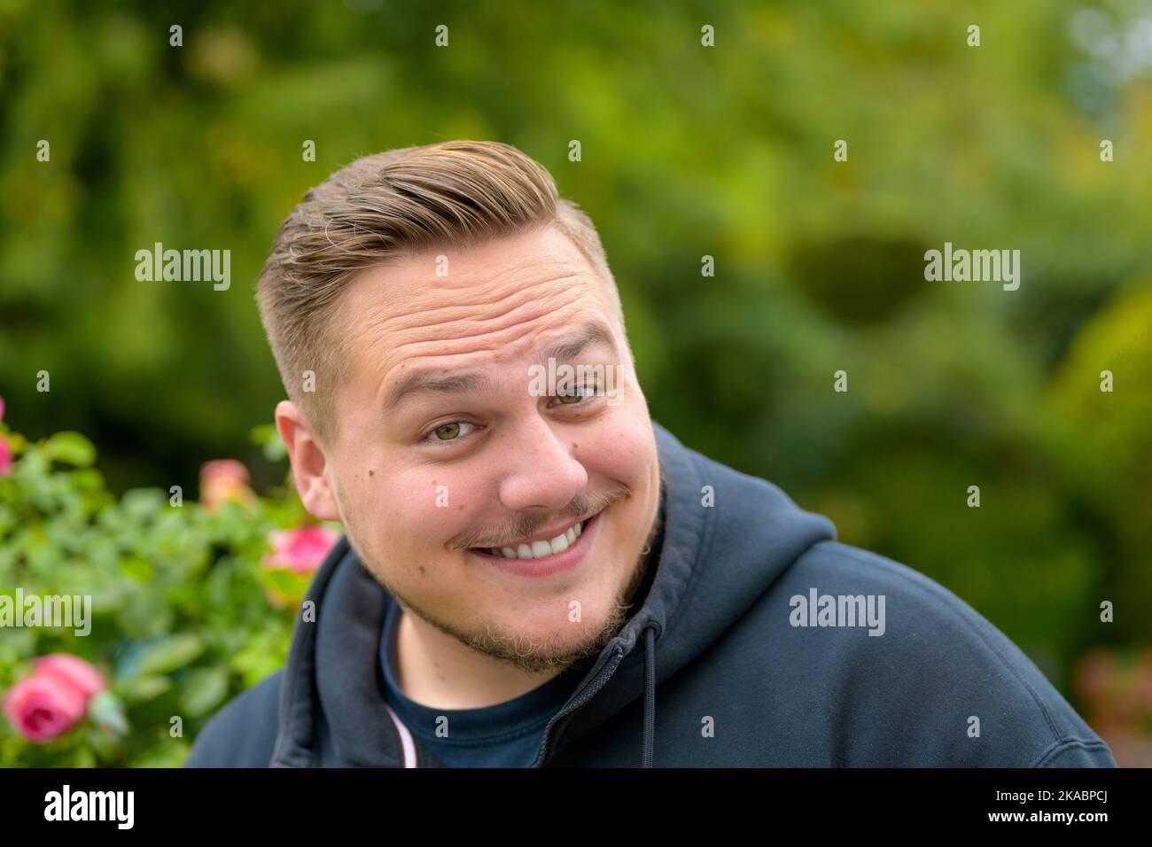 Young man looks at the camera with a mischievous smile in front of a ...