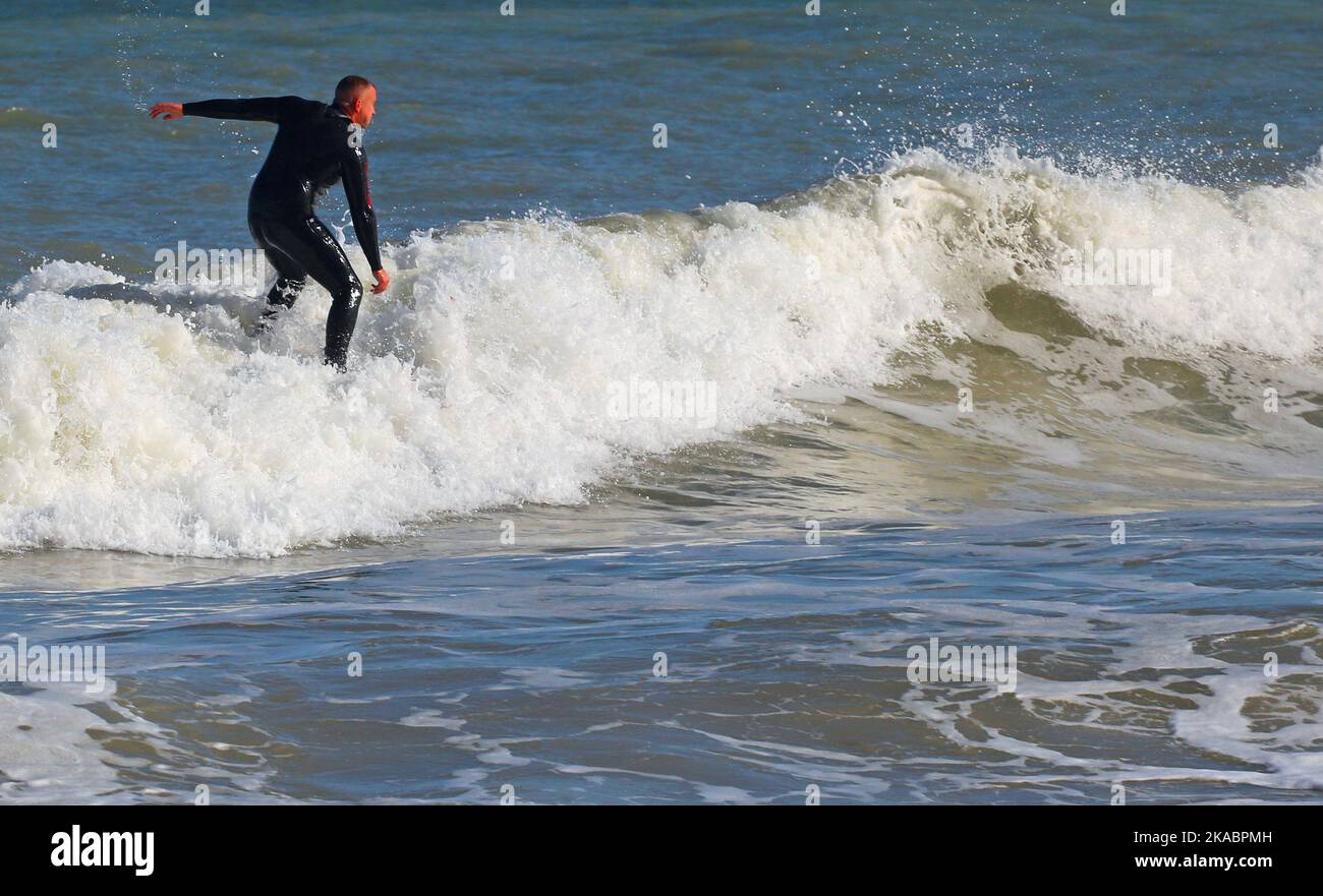 Man surfing a wave in the sea. Standing on a surfboard riding the white ...