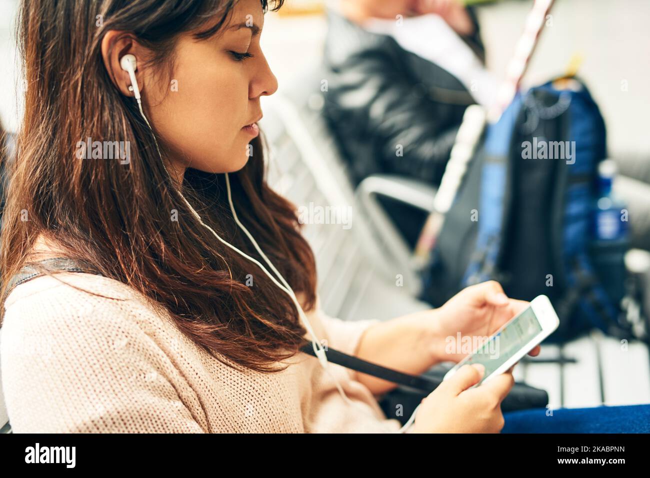 Passing the time with her smartphone. an attractive young woman using ...
