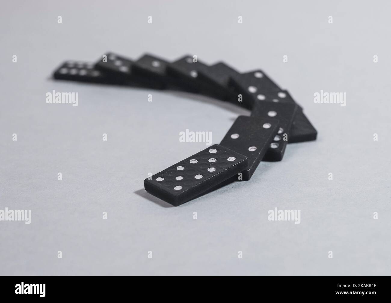 Domino game pieces falling on each other on gray blue backgound Stock ...