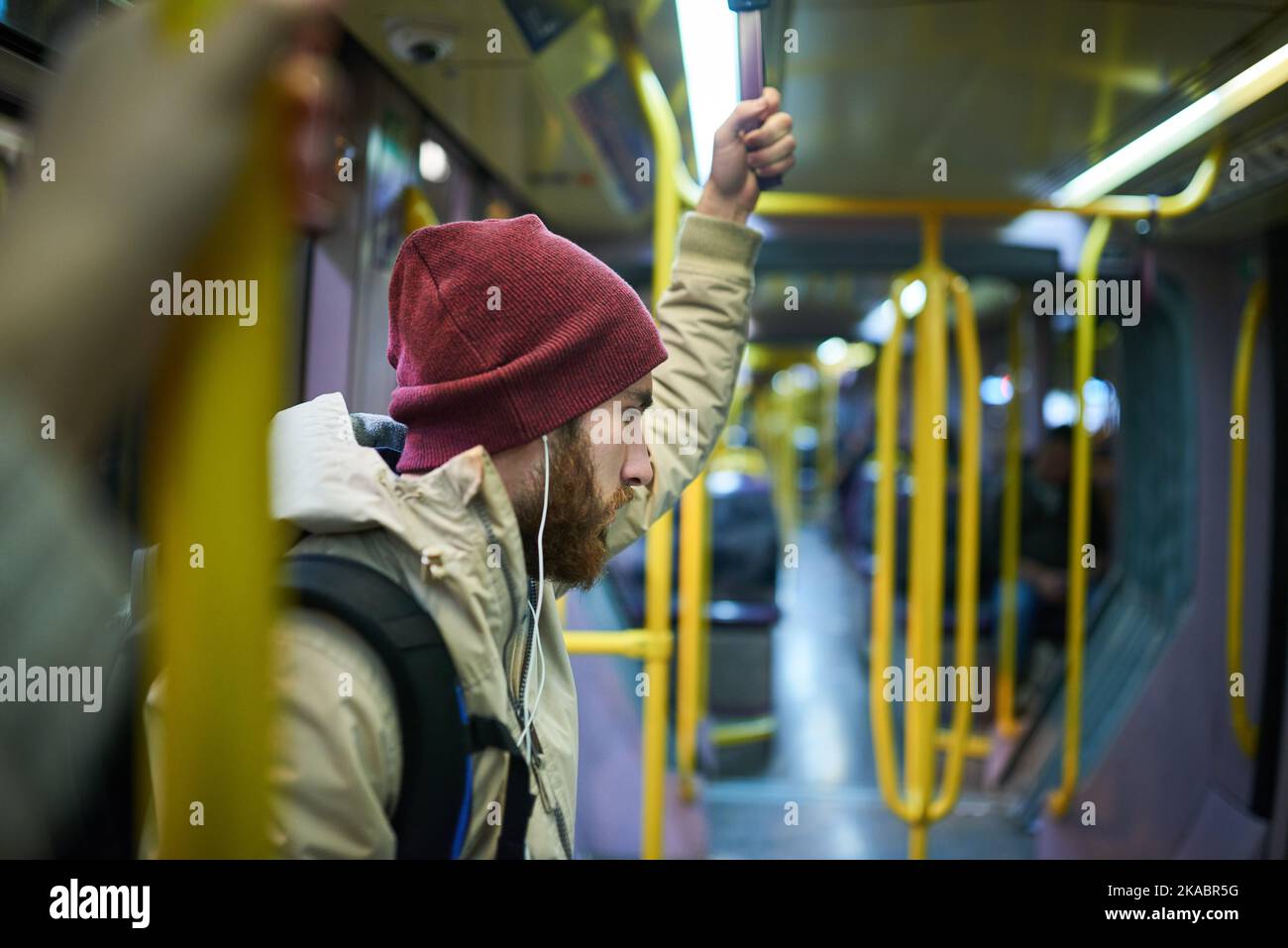 Just a little music to keep him company. a handsome young man listening to music on his ...