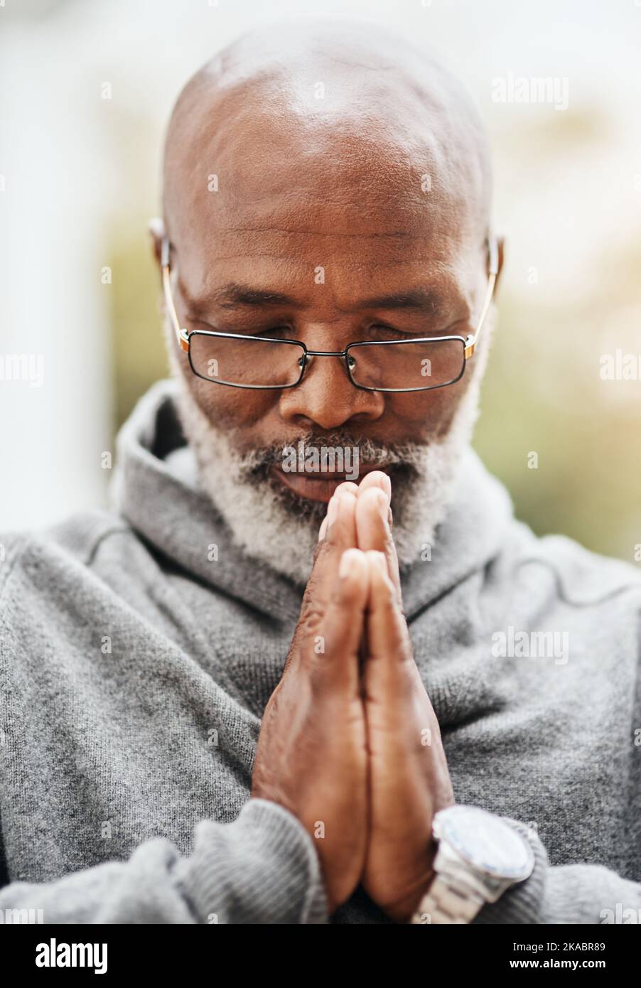 Praying for a few miracles in my life. a senior man holding his hands ...