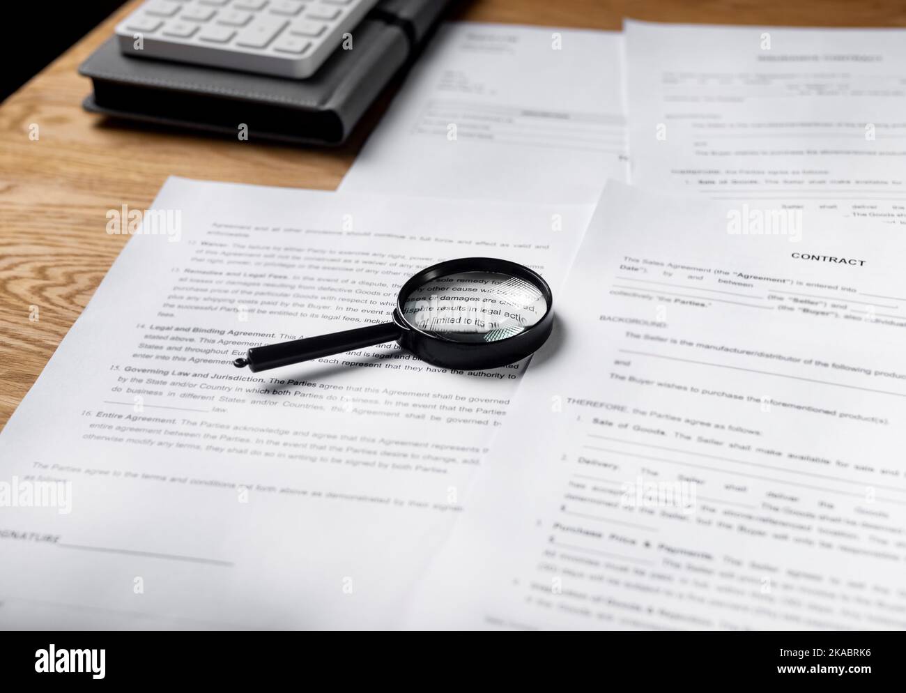 Paper contract and business documents on office desk with magnifying ...