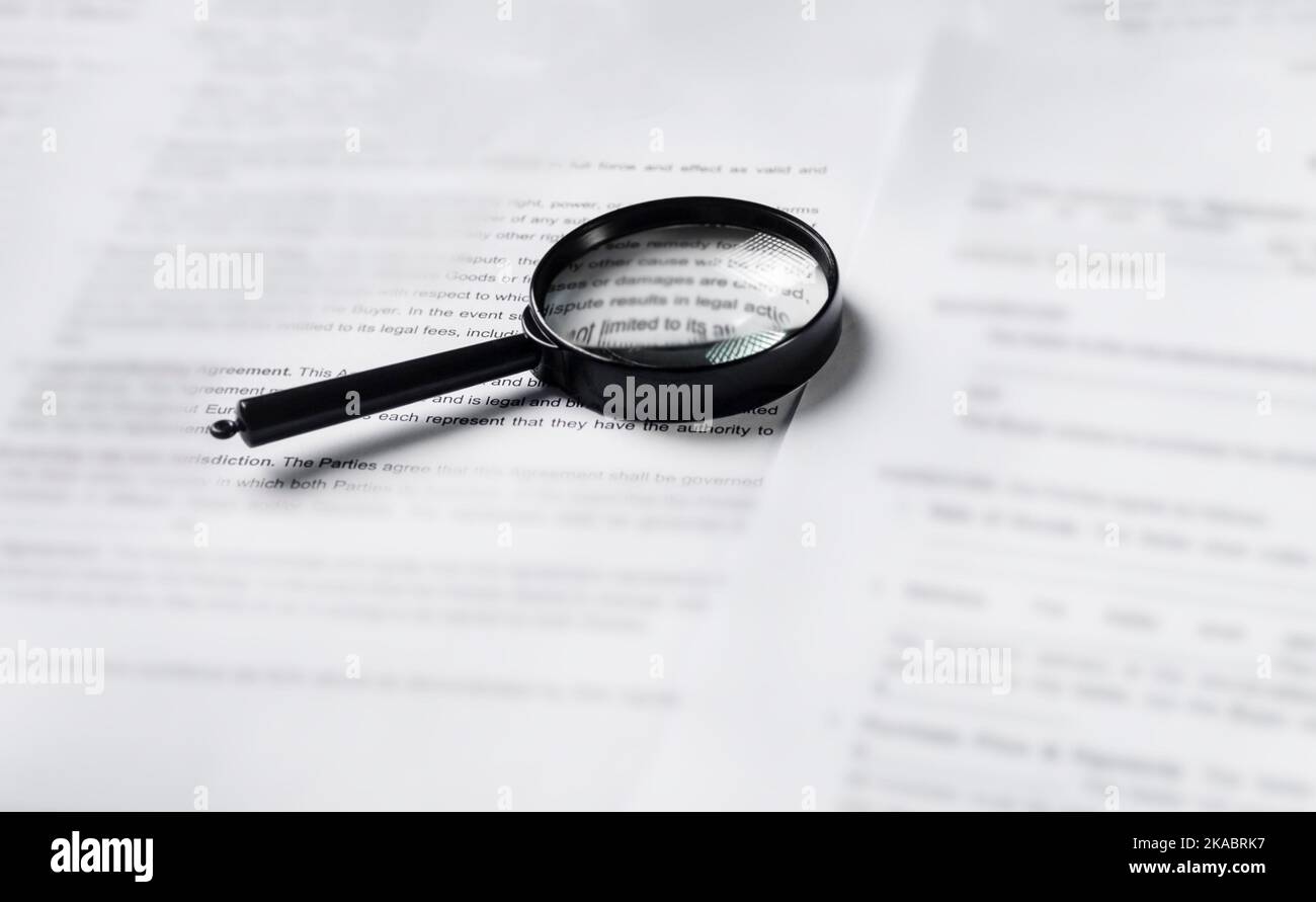 Magnifying glass lying over heap of paper documents. Investigation and ...