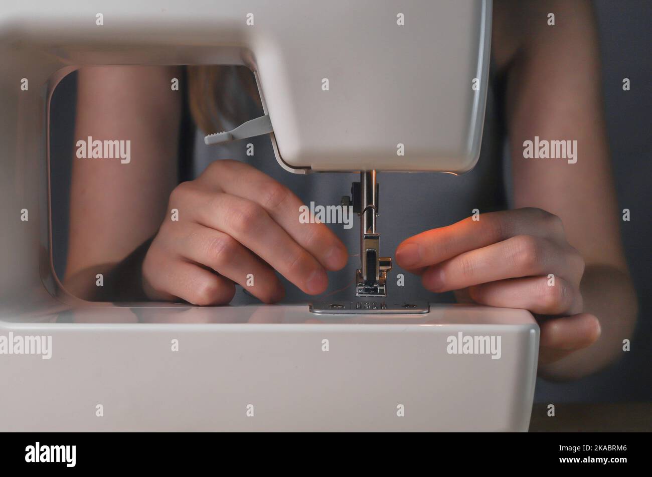 Hands inserting thread into hole of needle in sewing machine Stock ...