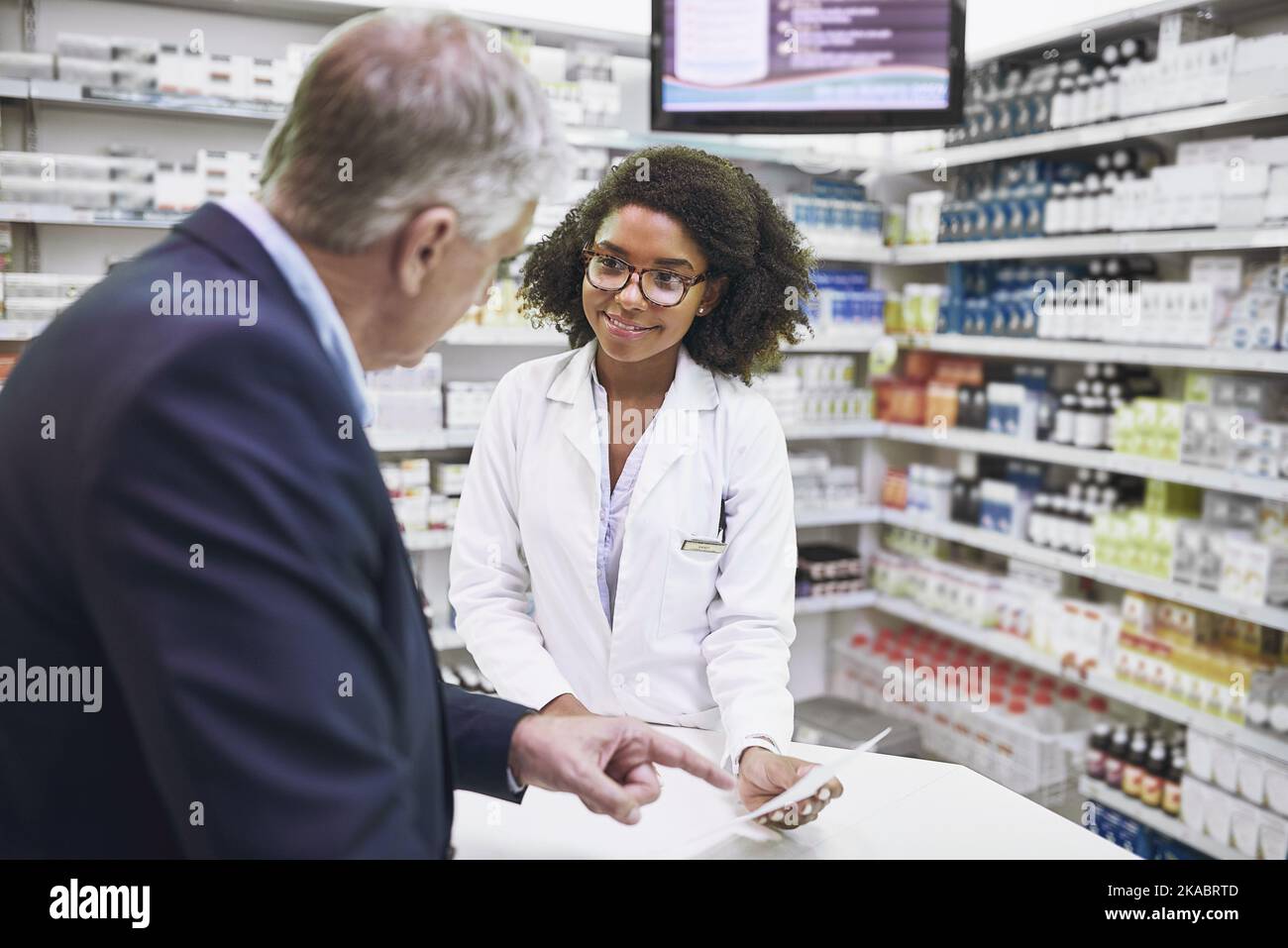 How many do I take daily. a cheerful young female pharmacist giving a ...