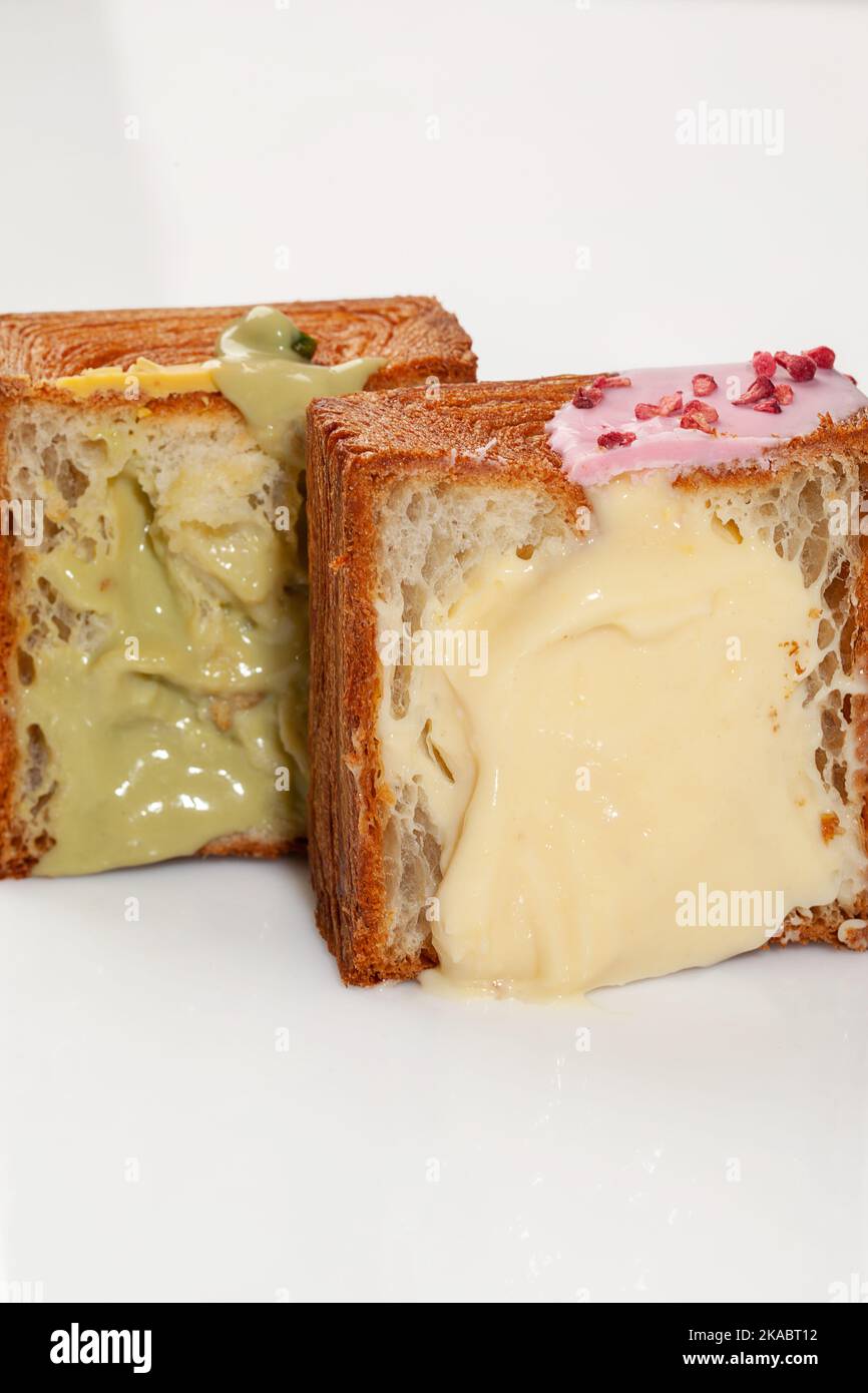 Two halves of cube croissants with pistachio cream, vanilla custard and ...