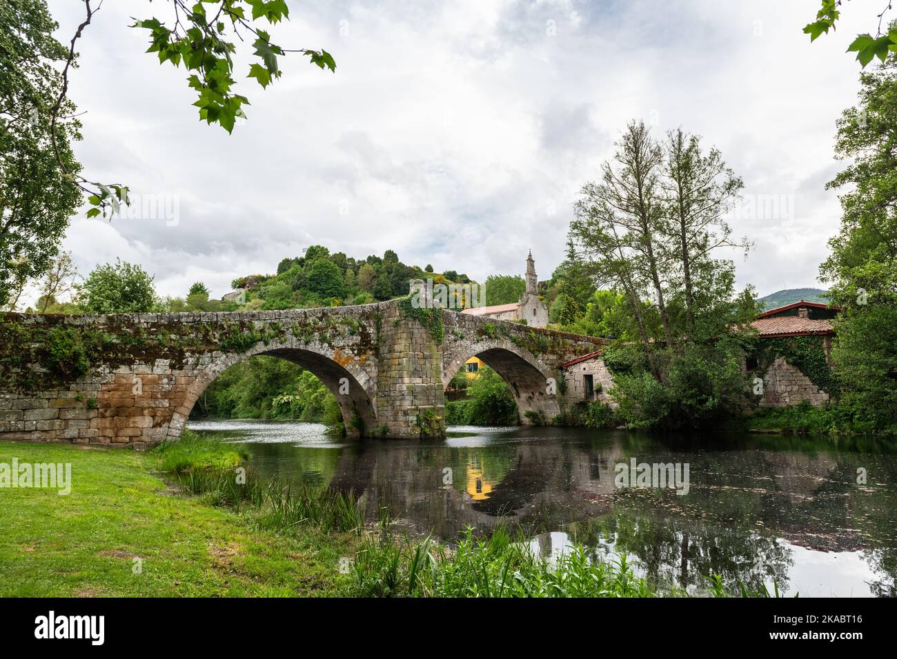 Medieval Roman bridge reflected on the water of the river Arnoia in the ...