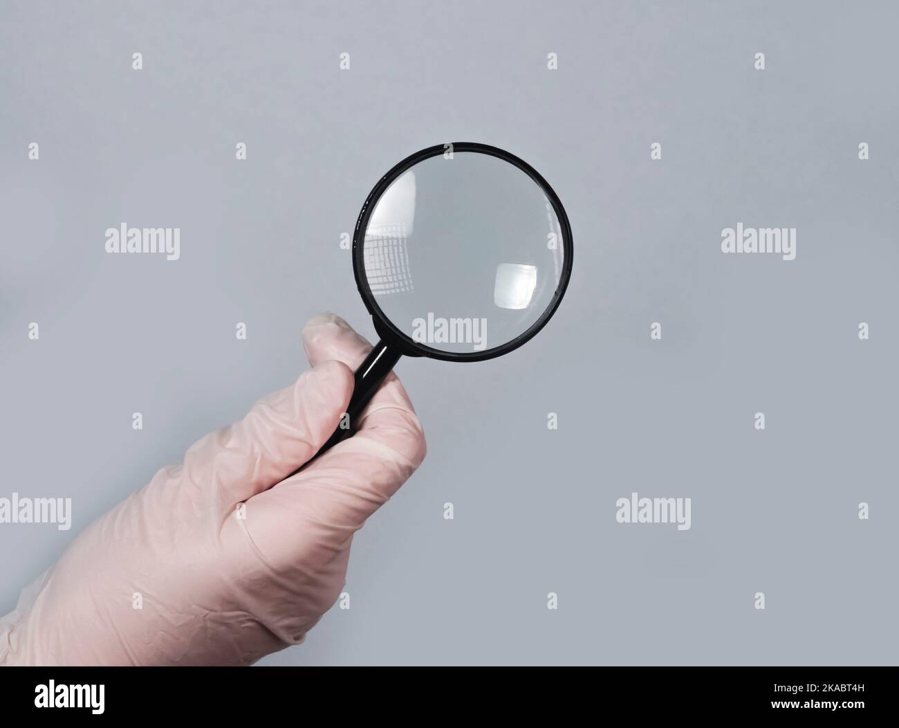Doctors hand hold magnifying glass, searching treatment and examining ...