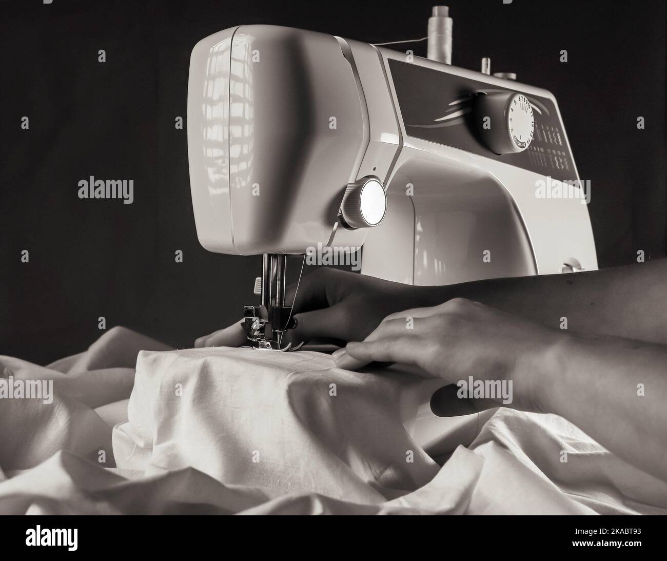 Hand at sewing machine during working process with textile Stock Photo ...