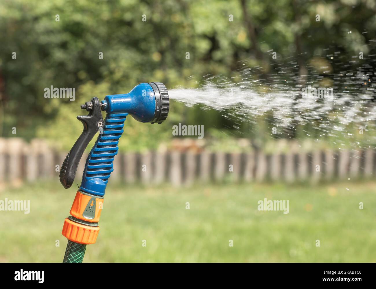 Lawn sprinkler in grass pouring watering grass with defocused drop and ...