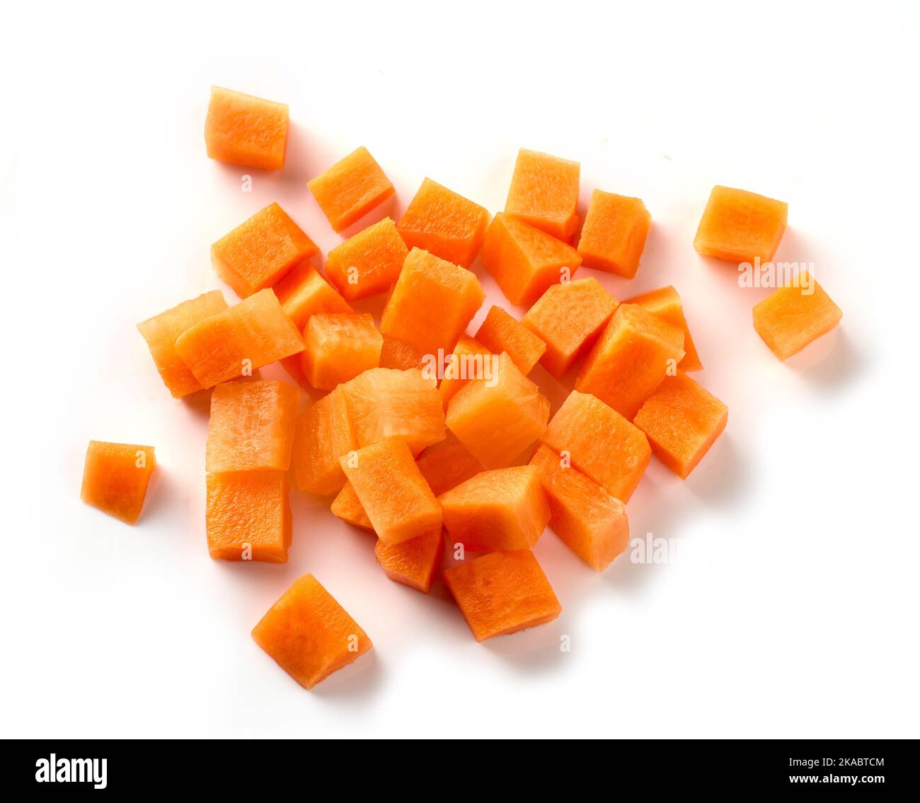 heap of fresh raw carrot cubes isolated on white background, top view ...