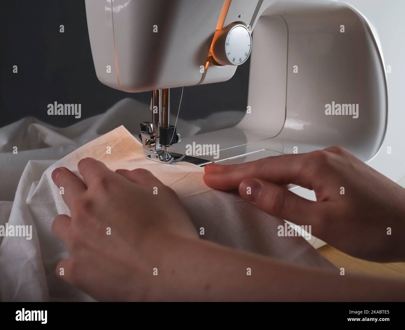 Seamstress hands with cloth at sewing machine during work Stock Photo ...