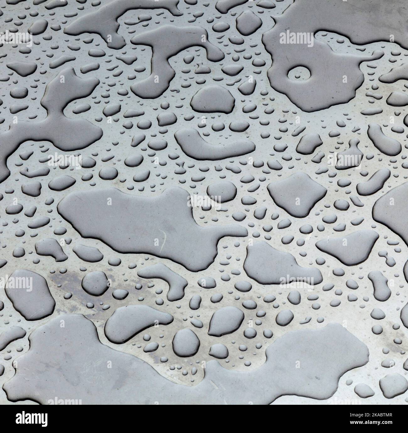 water on silver metal table in harmonic forma Stock Photo - Alamy