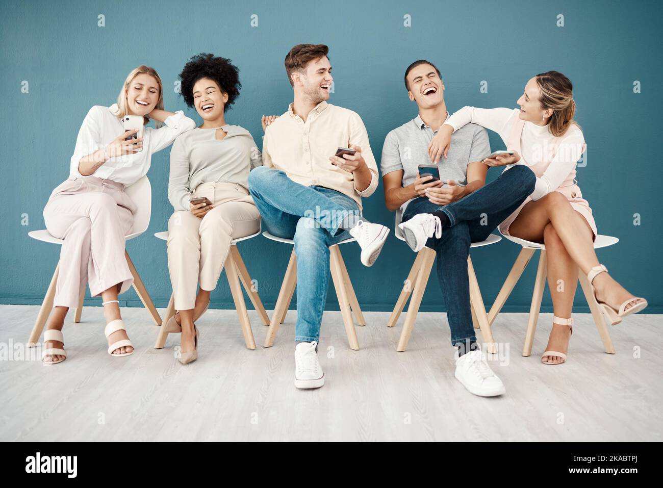 Hiring, phone and recruitment with people in a room waiting, laughing ...