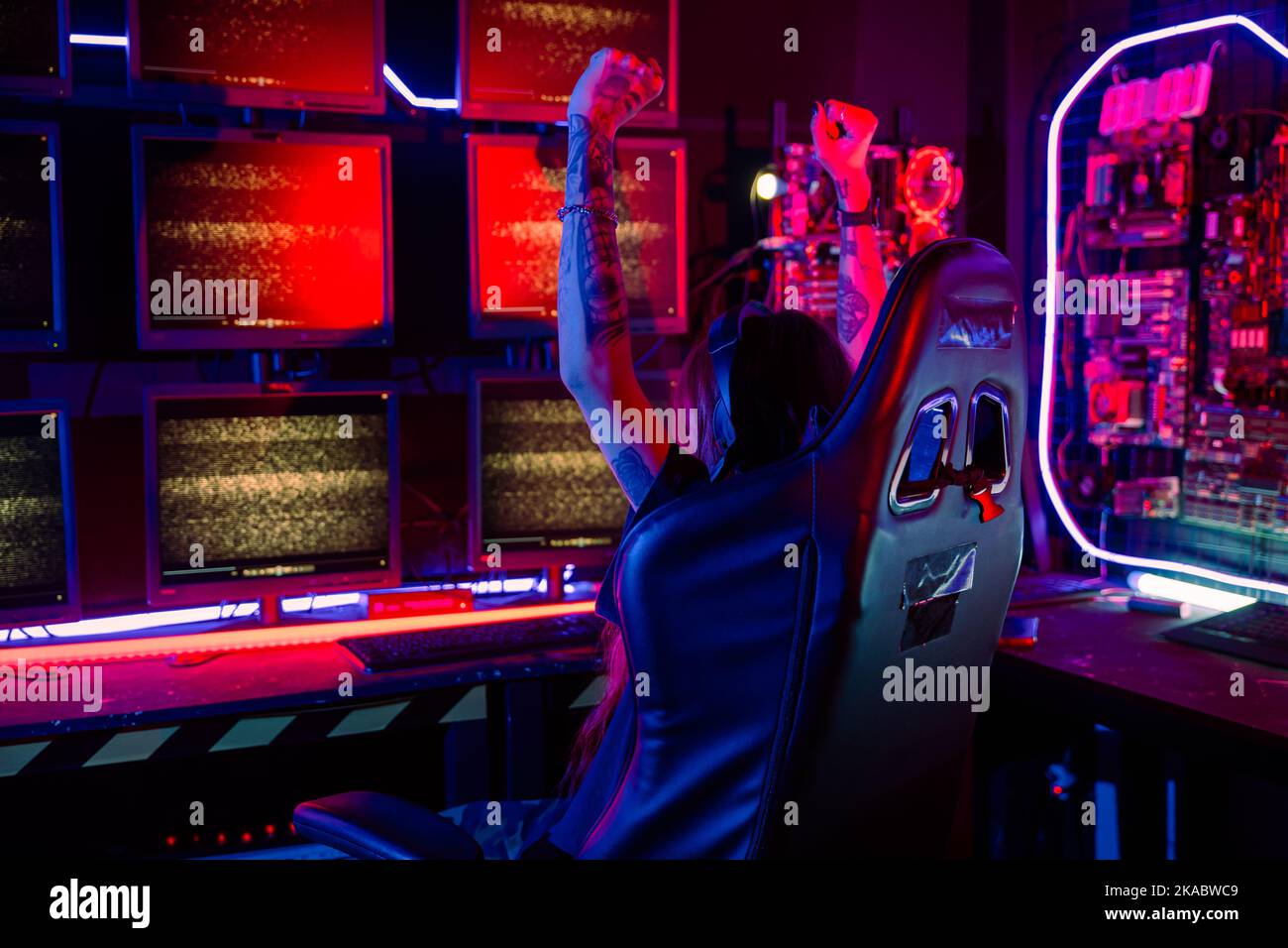 Happy Gamer young plays online video games computer she raises hands to ...