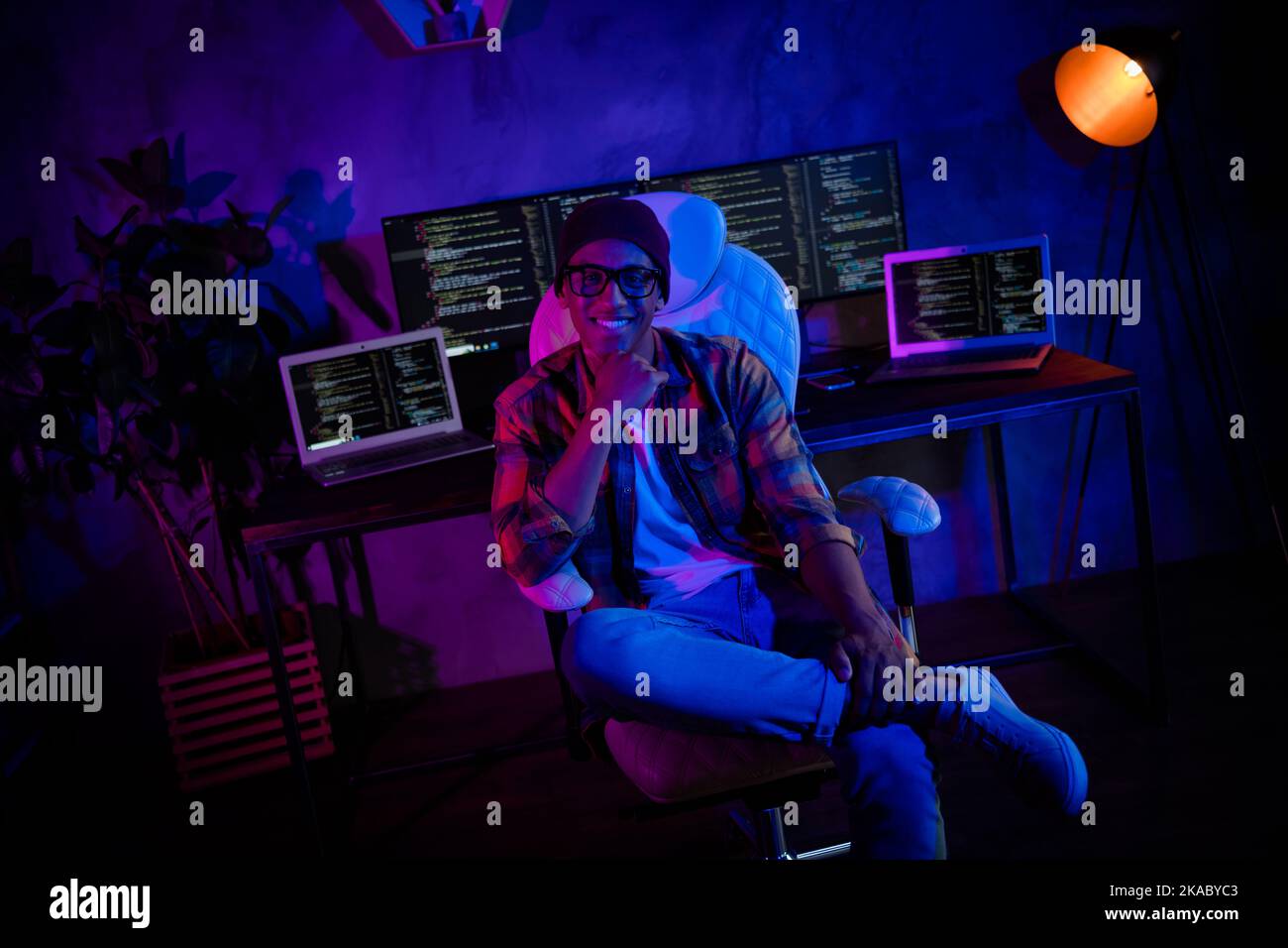 Photo of positive intelligent hacker sitting chair hand touch chin ...