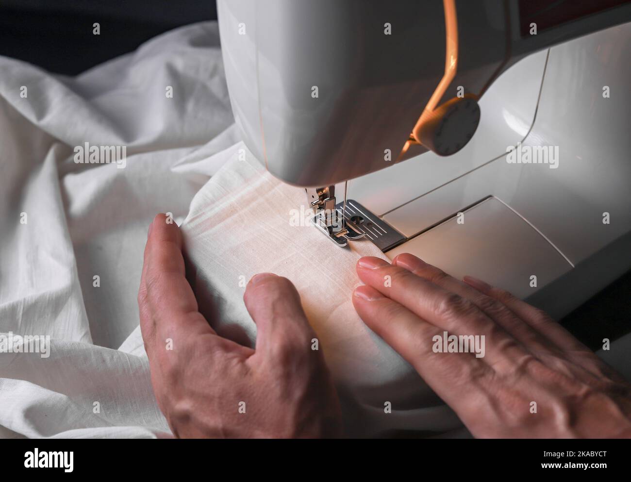 Male hands making stitch on textile on sewing machine. Manual tailoring ...