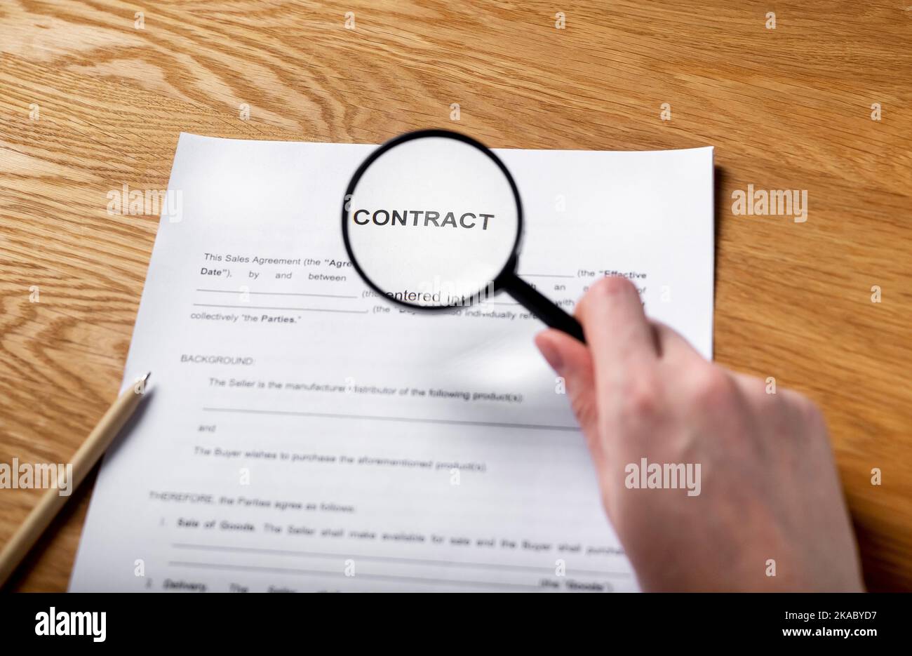 Paper contract on wood desk with magnifying glass in female hand Stock ...